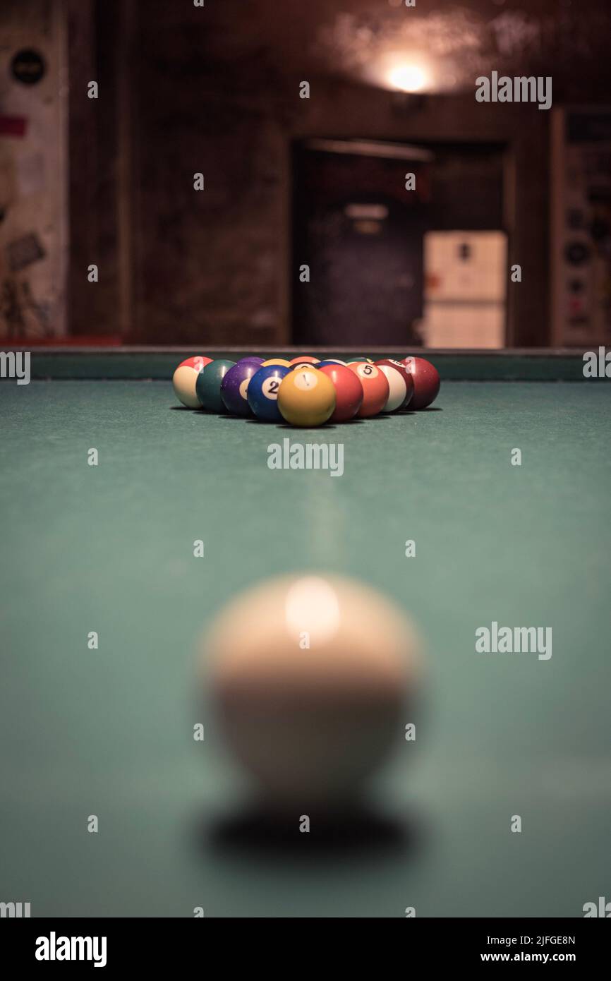A vertical selective focus shot of billiard balls placed on a table in ...