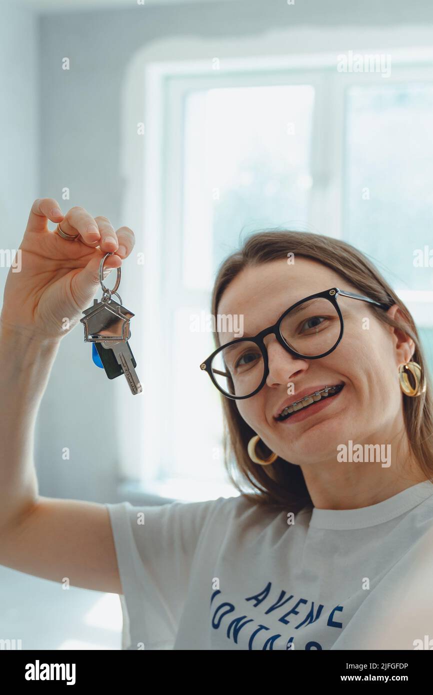 Happy woman tenant buyer moving to new home take selfie on phone camera ...