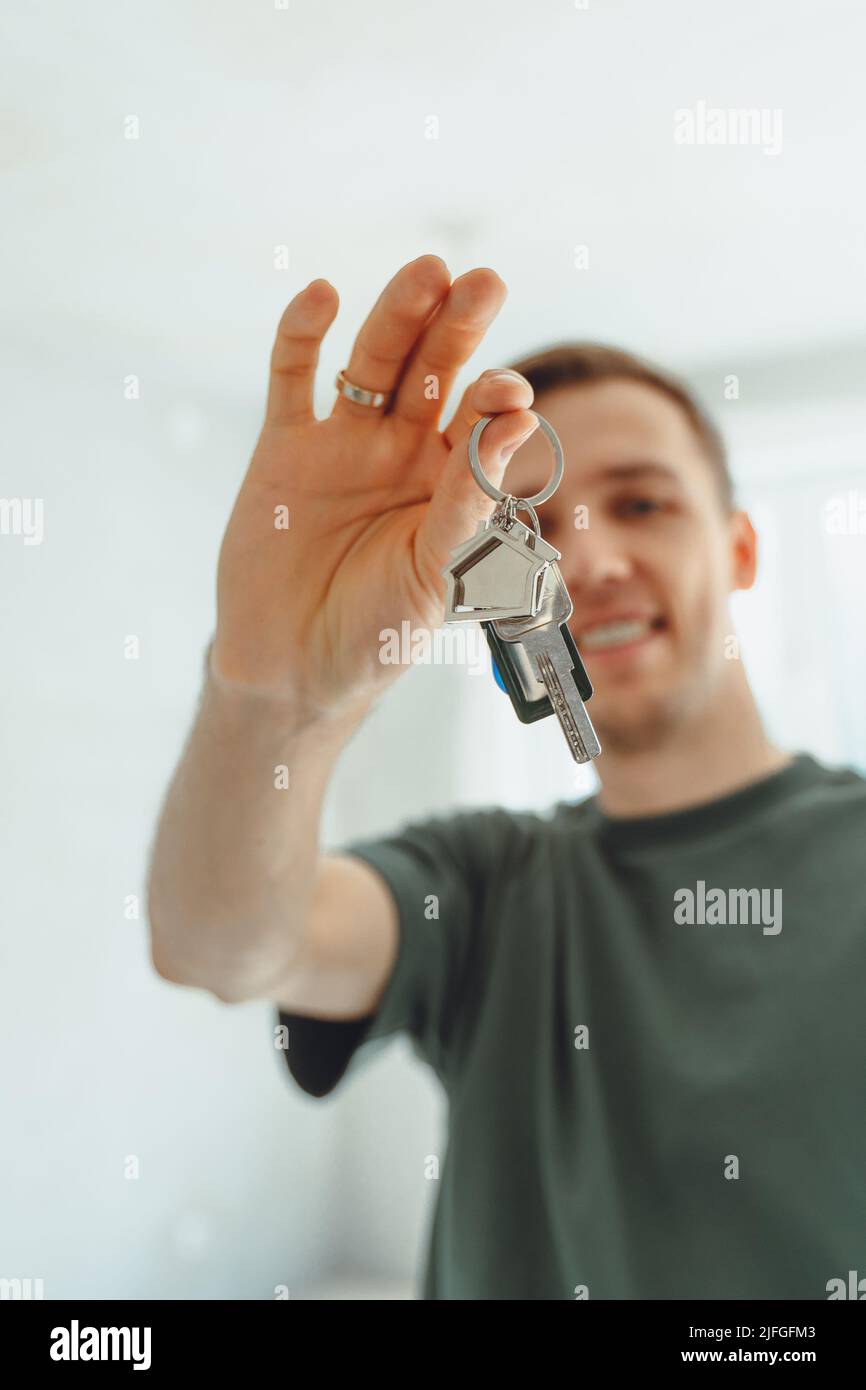 Close up blurred background of millennial male renter show new house ...
