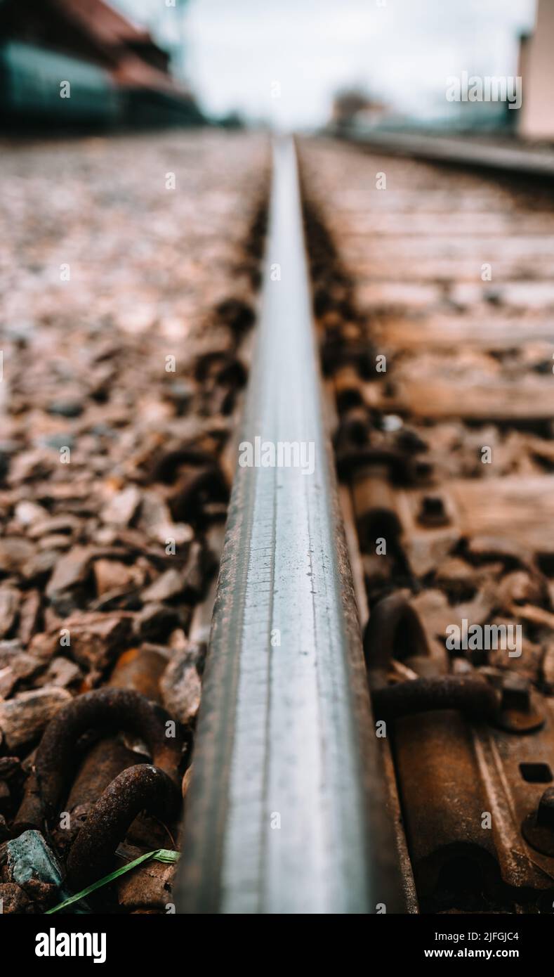 A vertical closeup of a metallic train railway detail covered with ...