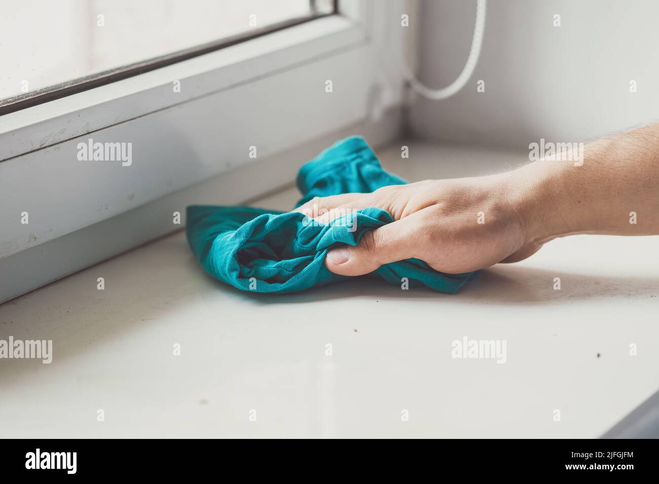 Male hand without gloves rubs dust from the windowsill. Mopping with a ...