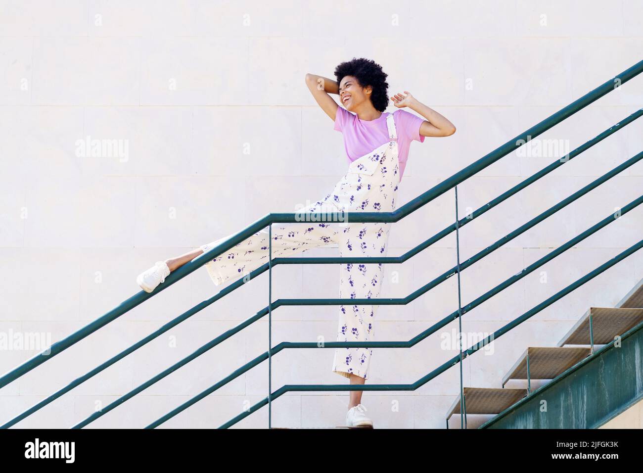 Happy black woman standing on staircase Stock Photo - Alamy