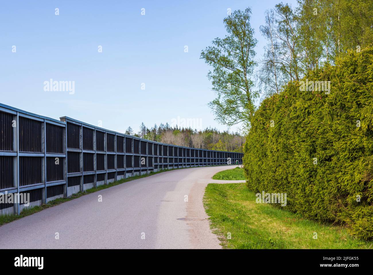 View of high fence protecting cottage village from motorway noise ...