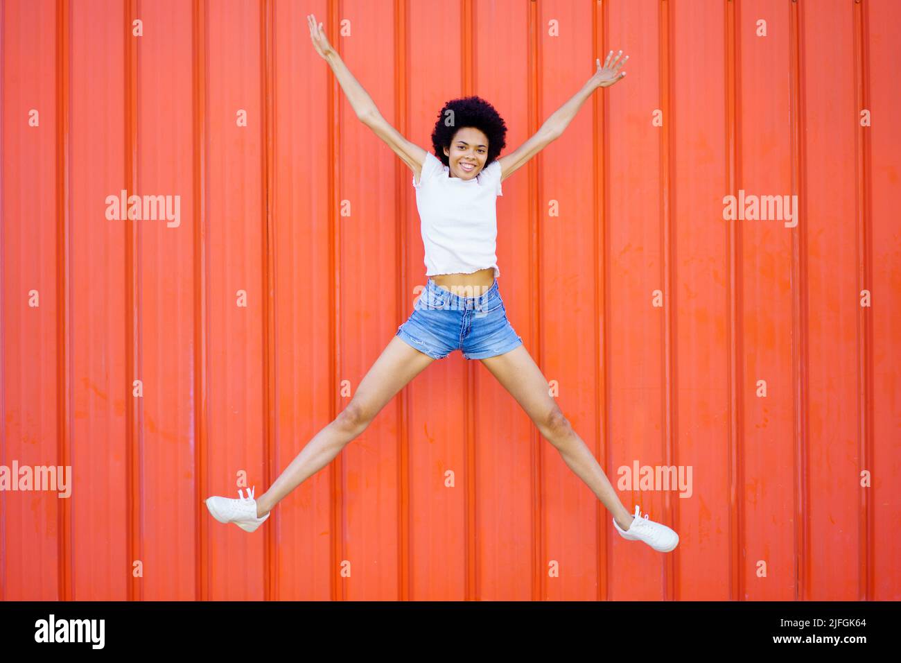Happy black woman jumping on street Stock Photo - Alamy