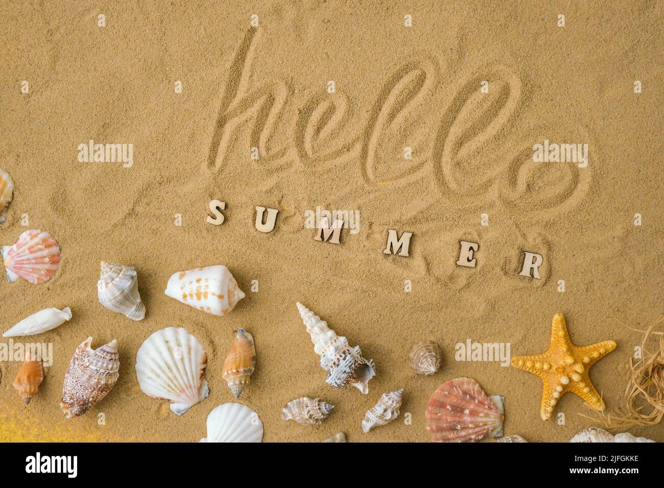 Composition with text HELLO SUMMER seashells, pebbles, mockup on sand ...
