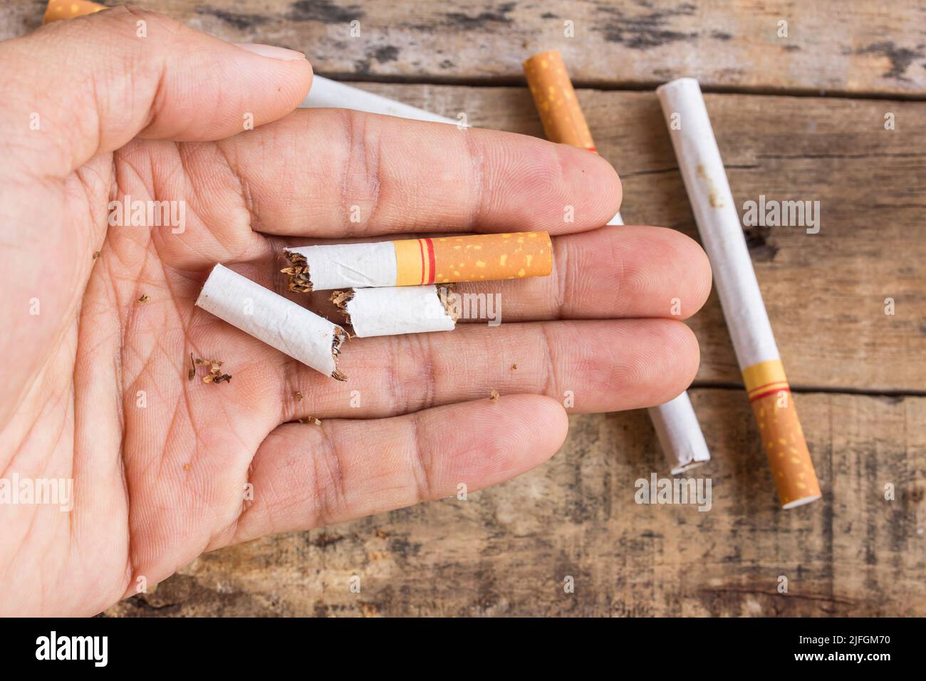 Close up cigarette roll in hand holding Stock Photo - Alamy