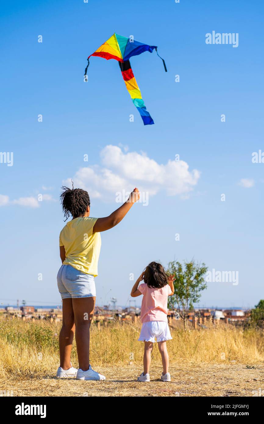 mother and daughter flying a colorful kite in the countryside Stock ...
