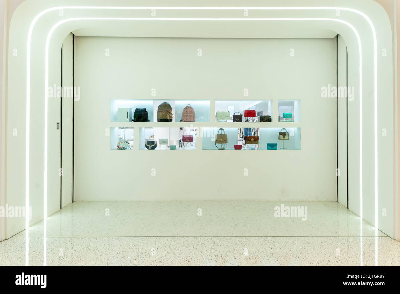 A showcase of bags in fashion store with white interior Stock Photo - Alamy