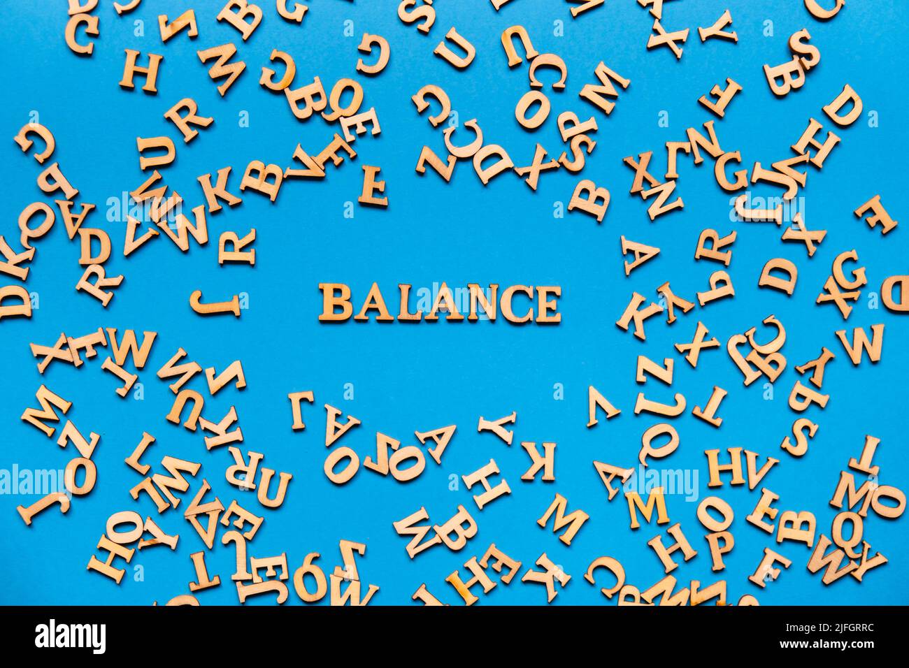 Word BALANCE made out of wooden letters on bright blue background ...