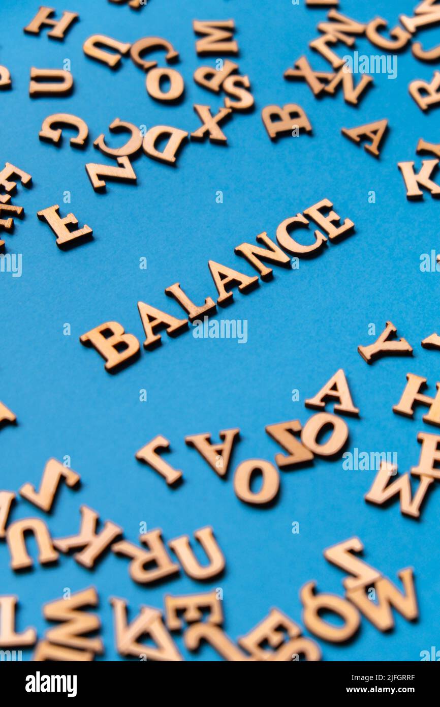Word BALANCE made out of wooden letters on bright blue background ...