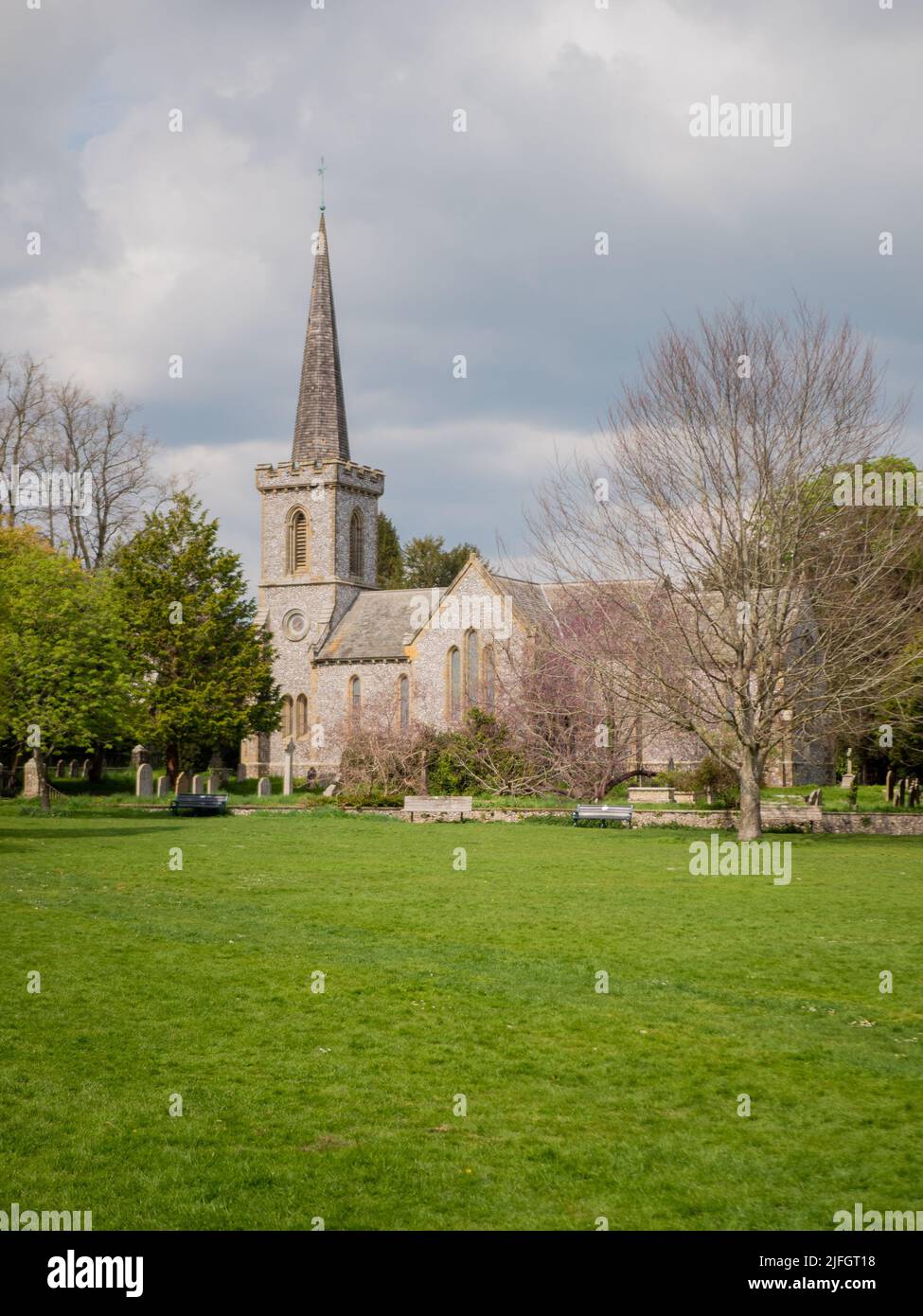 A Stanmer church surrounded by growing trees and greenery field in ...