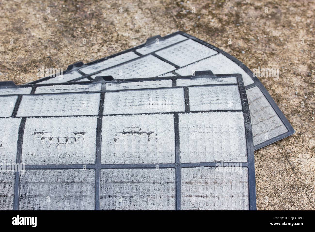 Dirty dust filters of air conditioner ready for cleaning on the ground ...