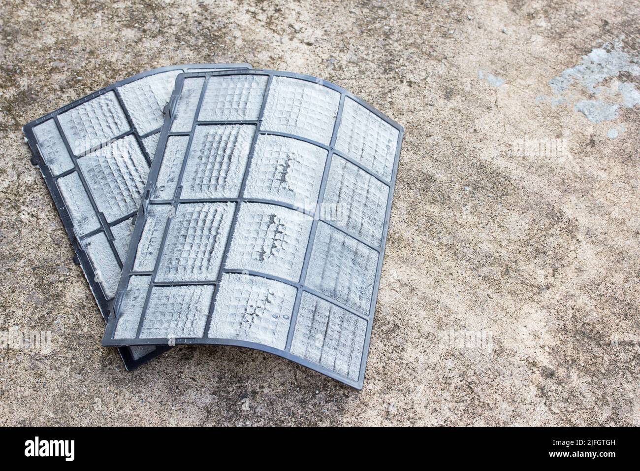 Dirty dust filters of air conditioner ready for cleaning on the ground ...