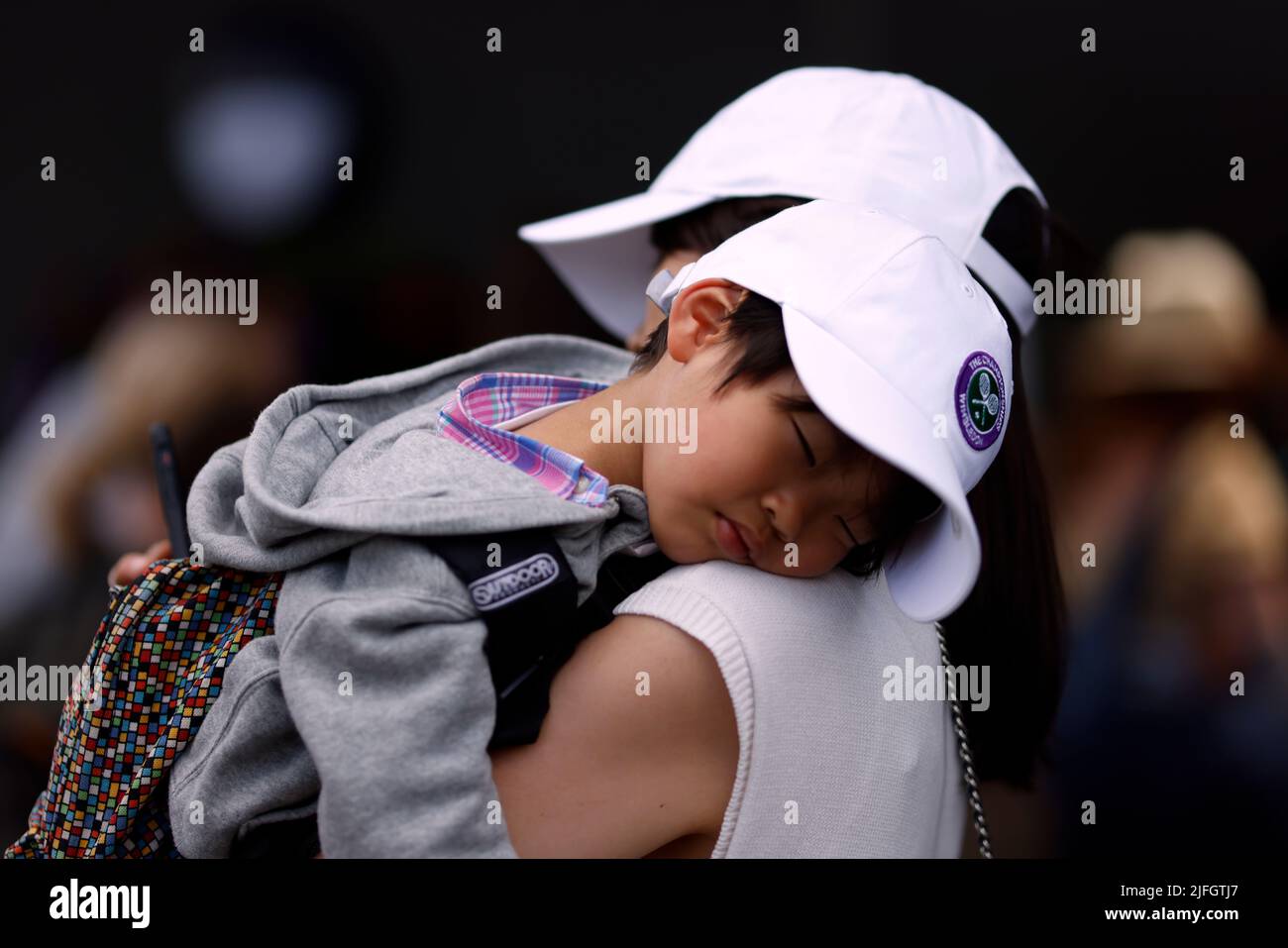 A young sleeping spectator is carried around the grounds during day ...