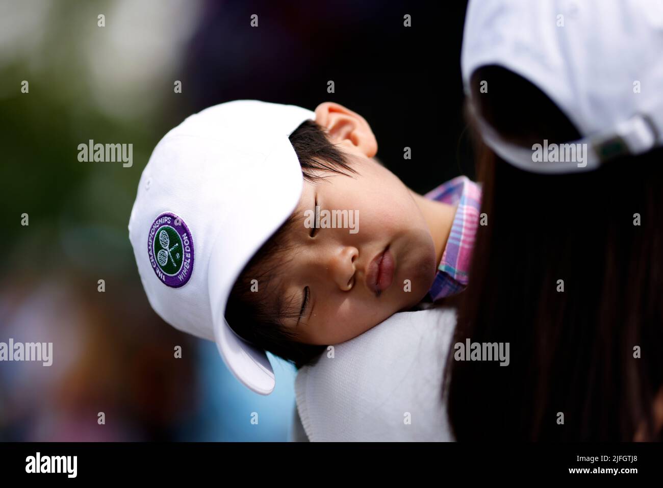 A young sleeping spectator is carried around the grounds during day ...