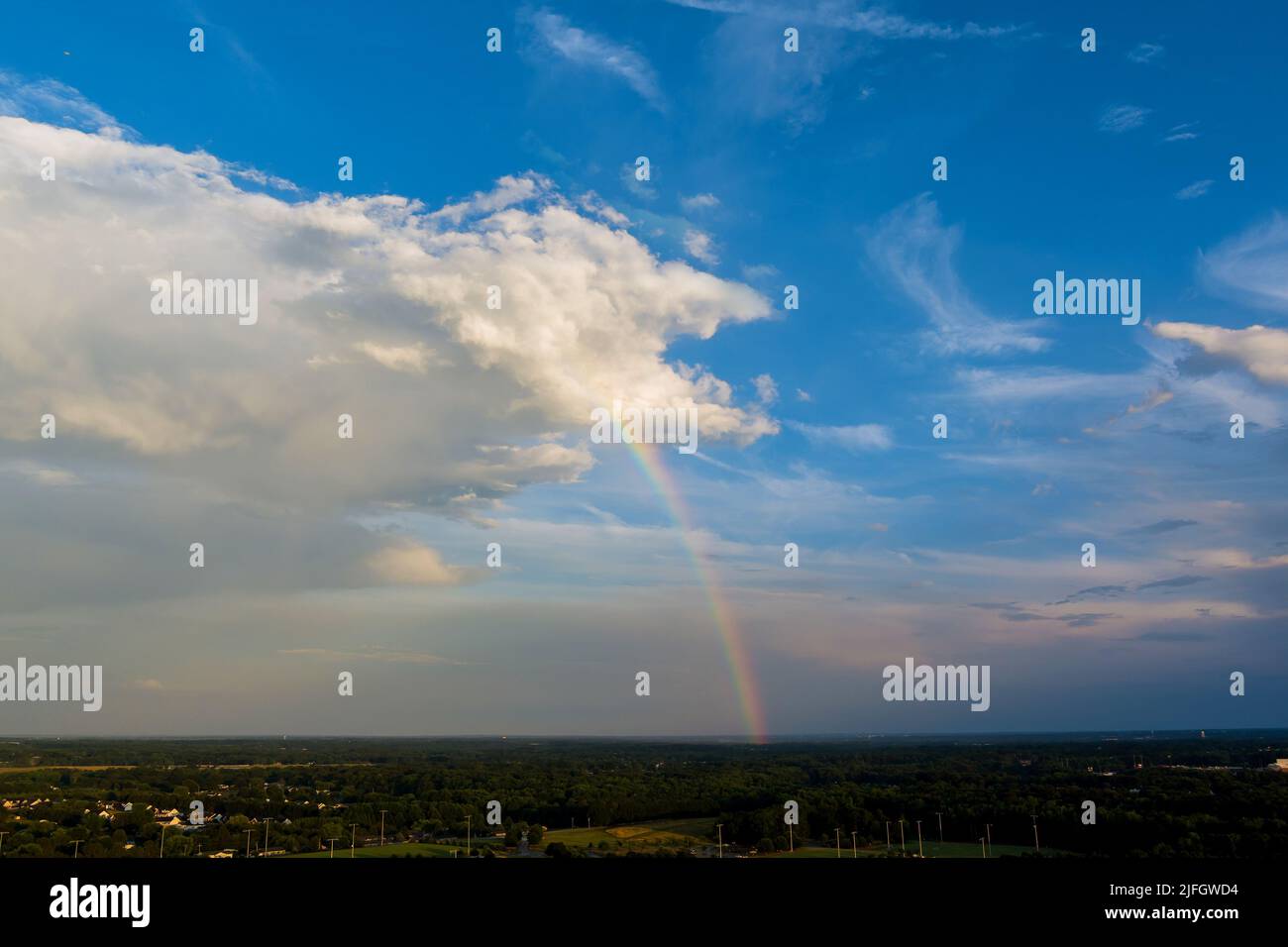 After rain, a beautiful panorama features a multicolored rainbow with ...