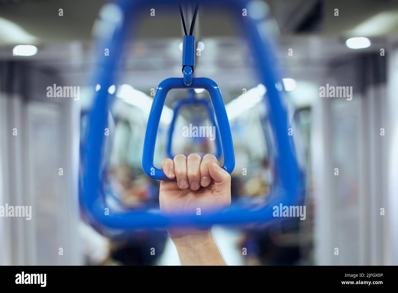 Hand holding handle in train of public transportation Stock Photo - Alamy