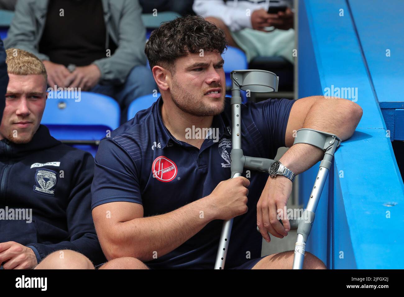 Joe Philbin #8 of Warrington Wolves sits on the bench with crutches ...