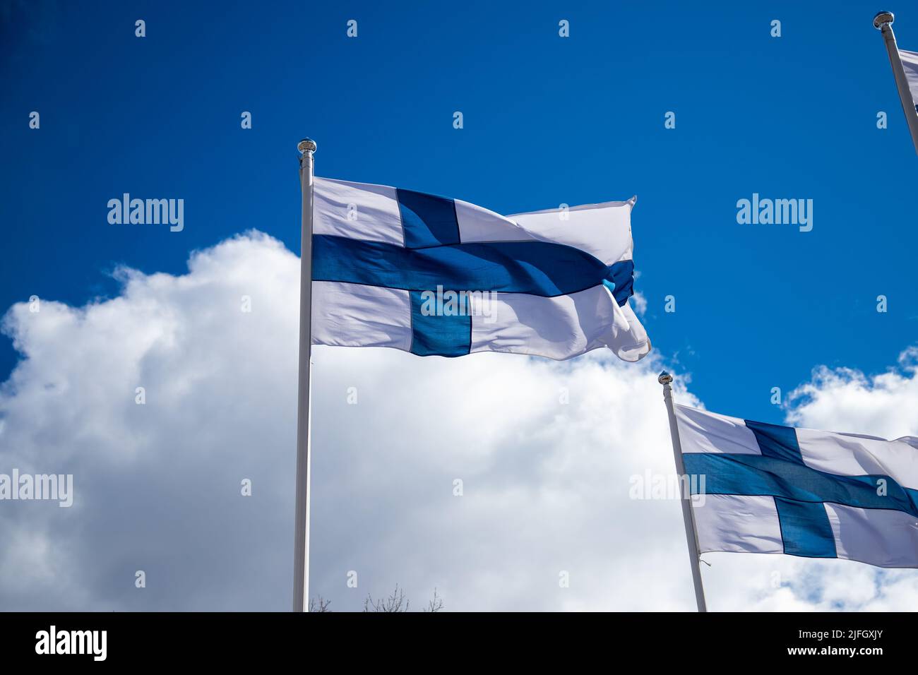 A Finland flags waving on a flag pole in background of cloudy sky Stock ...