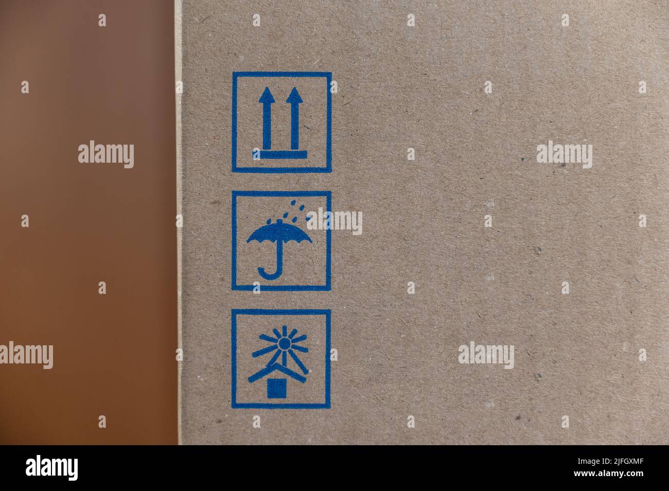 Markings on the cardboard box. Three blue shipping symbols. Top ...