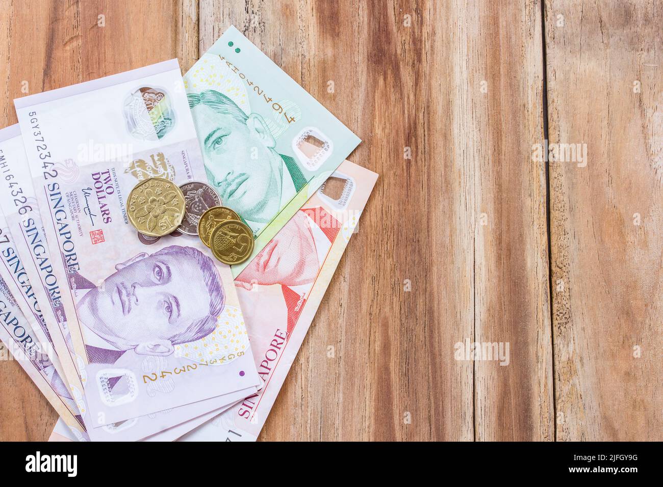 Singapore money on wooden table background, various of singapore dollar ...