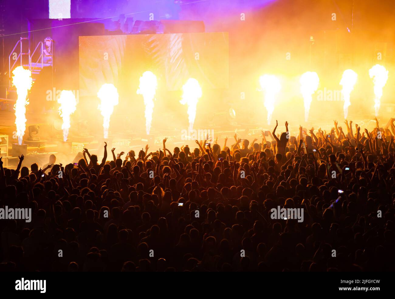 Crowd at concert - Cheering crowd in bright colorful stage lights Stock ...