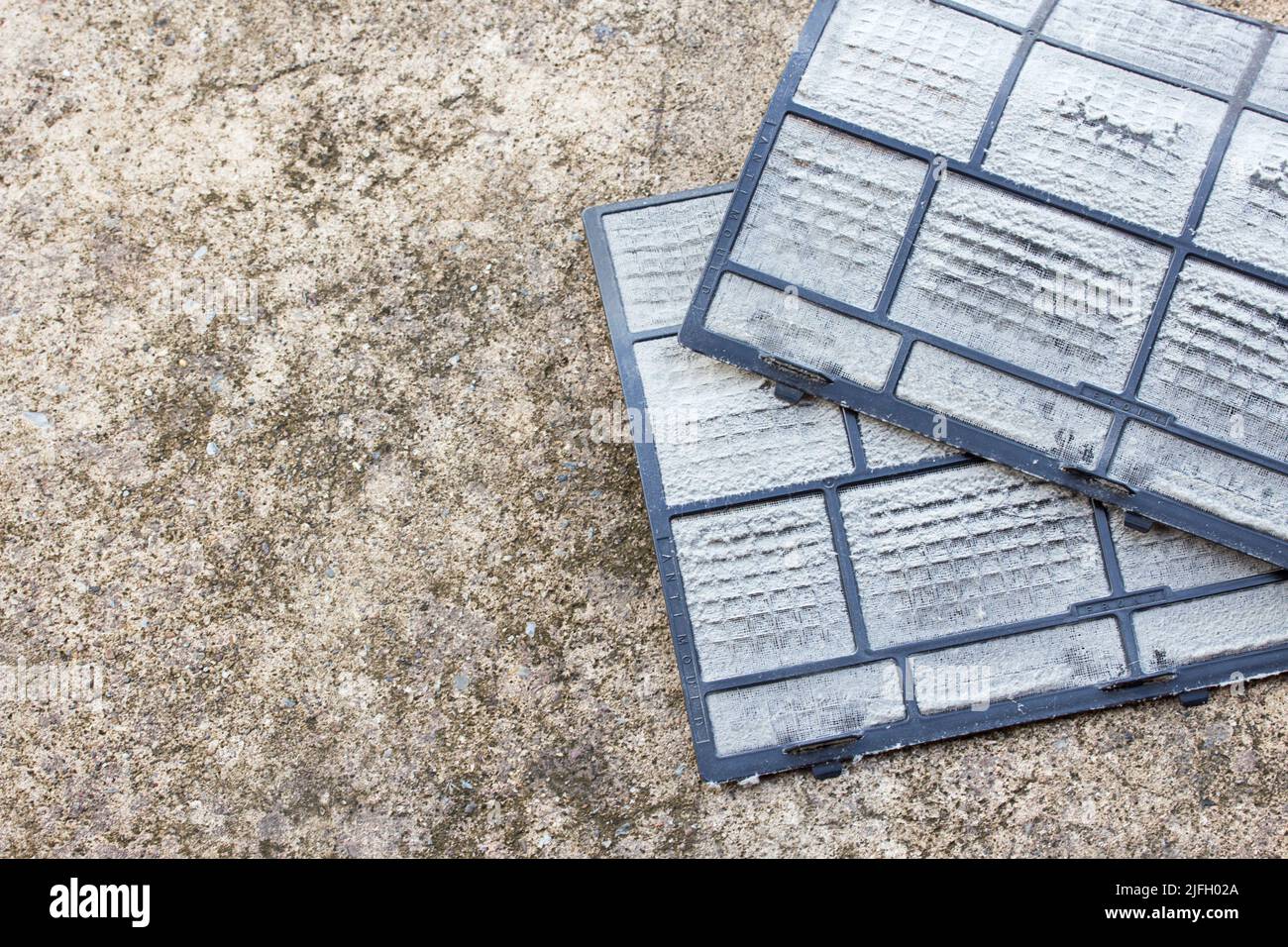 Dirty dust filters of air conditioner ready for cleaning on the ground ...