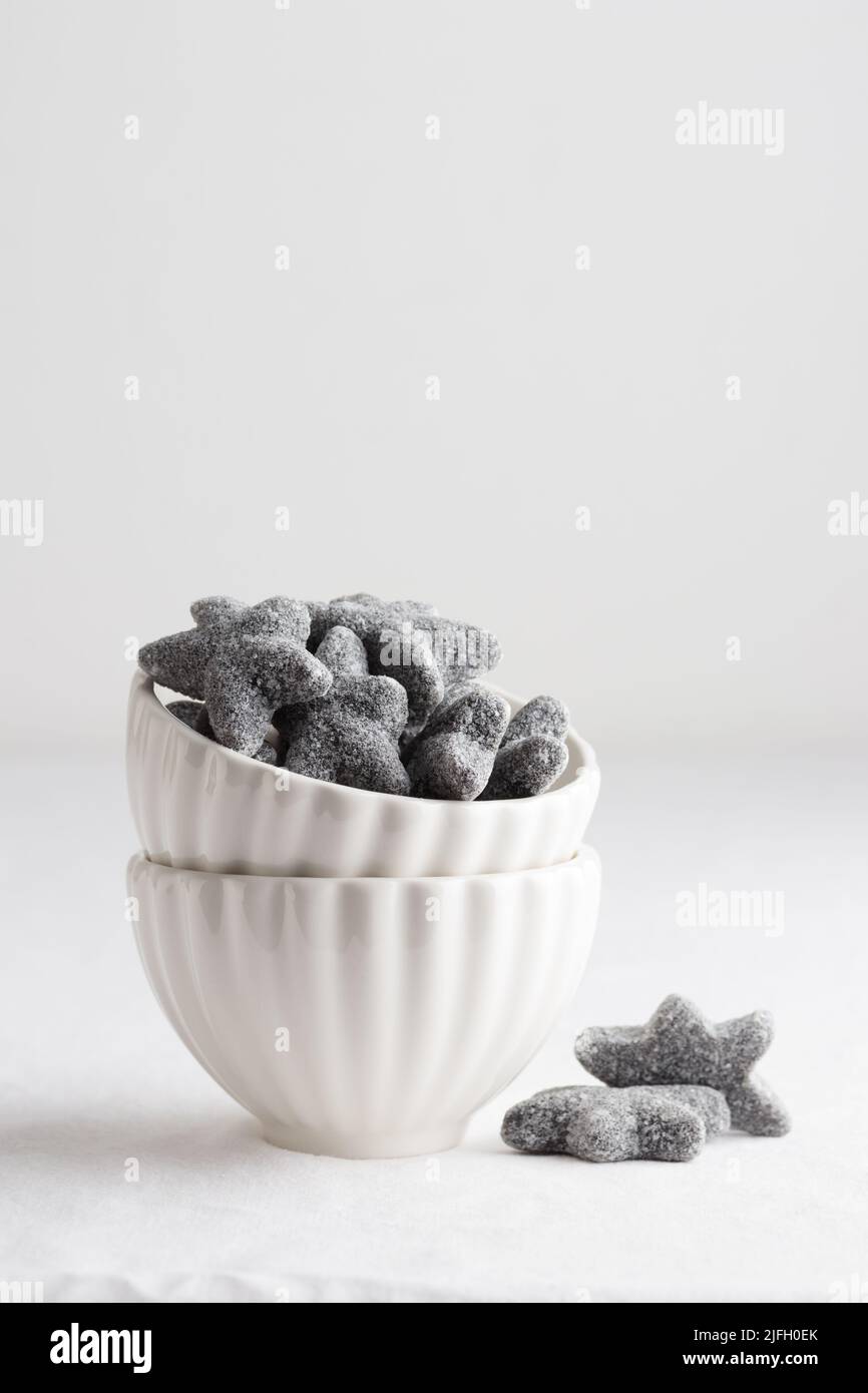 Salty liquorice salmiakki in Finnish in a white bowl with copy space ...