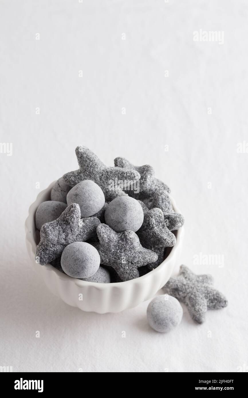 Salty liquorice salmiakki in Finnish in a white bowl with copy space ...