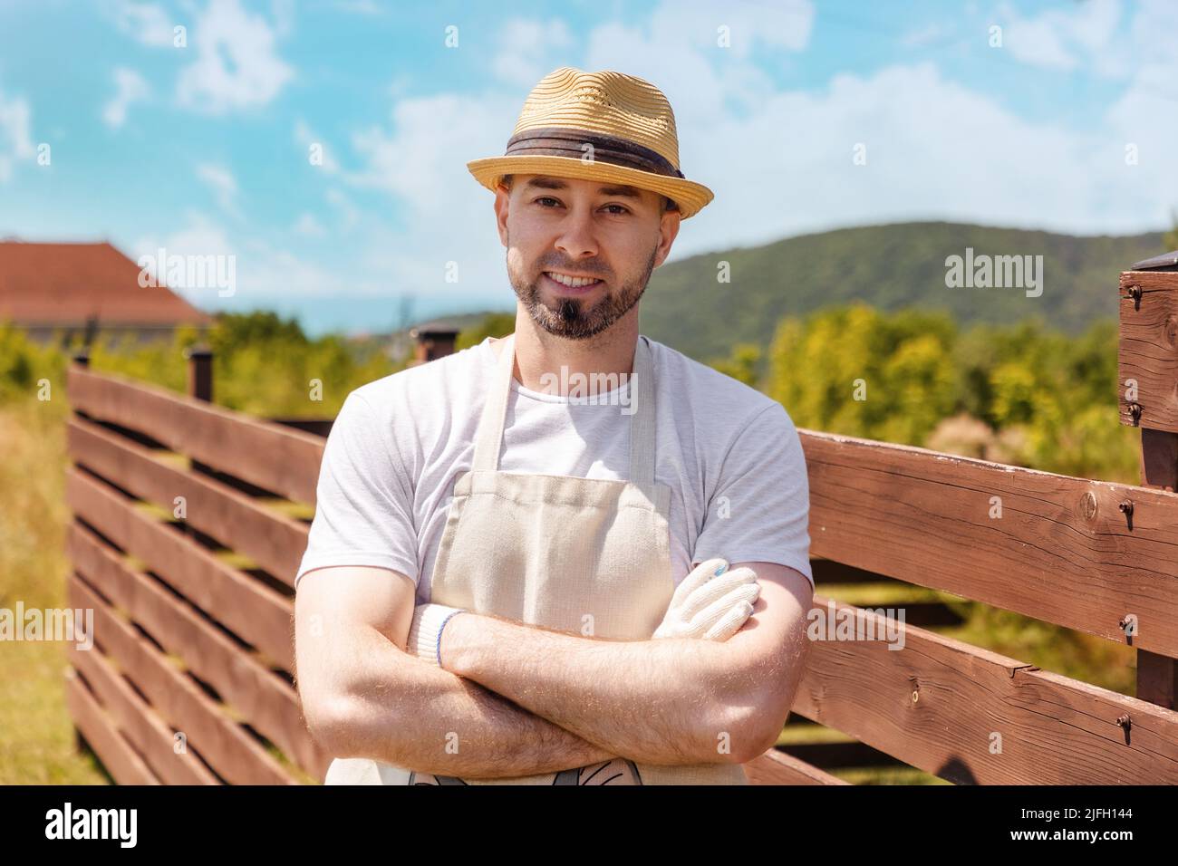 Portrait of a smiling handsome Caucasian bearded man in a straw hat ...