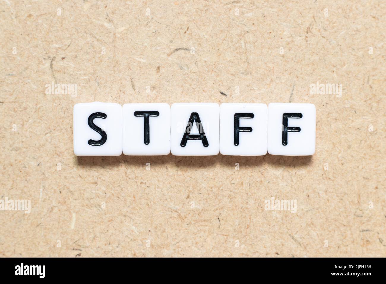 White tile alphabet letter with word staff on wood background Stock ...