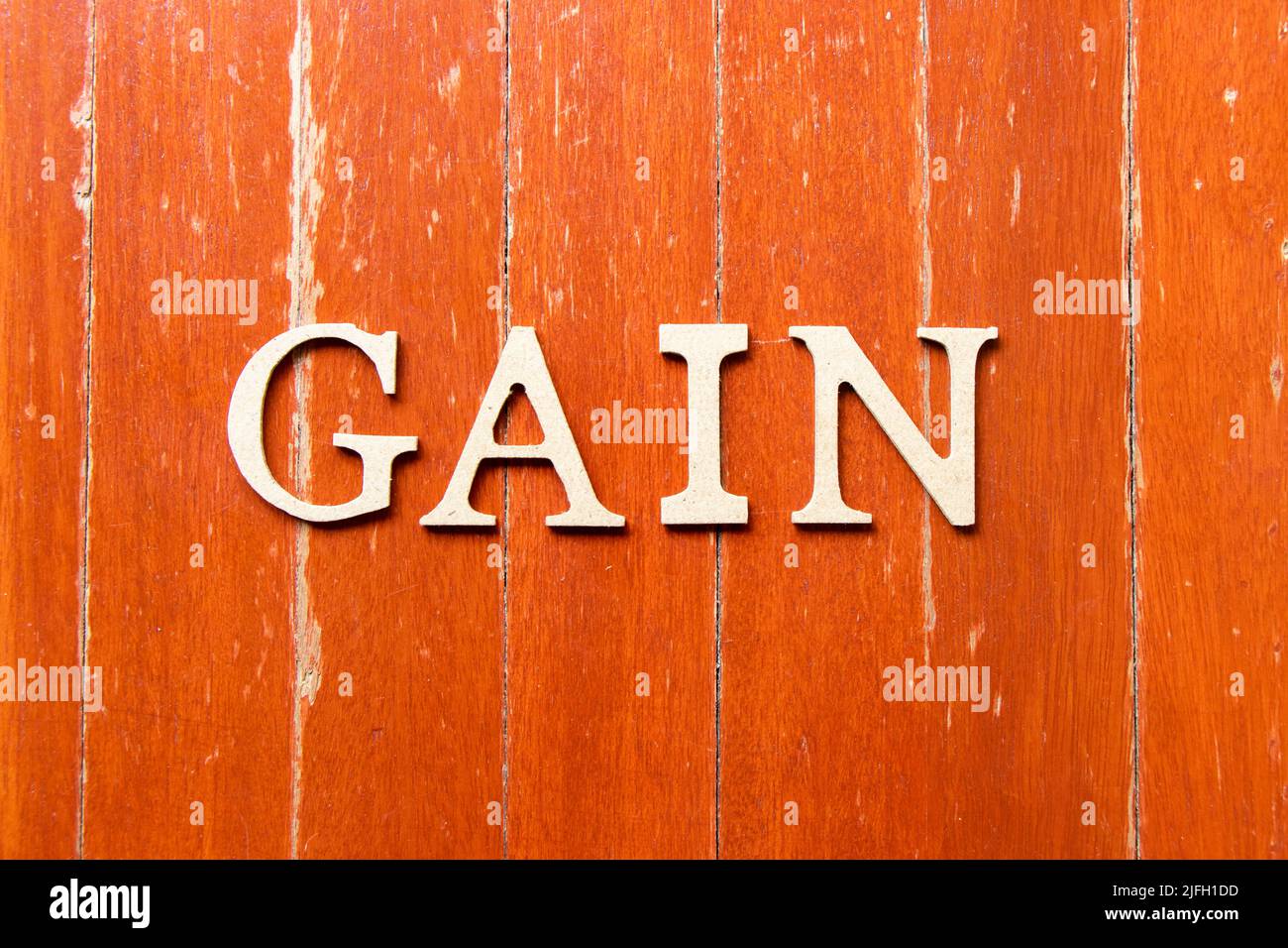 Alphabet letter in word gain on old red color wood plate background ...
