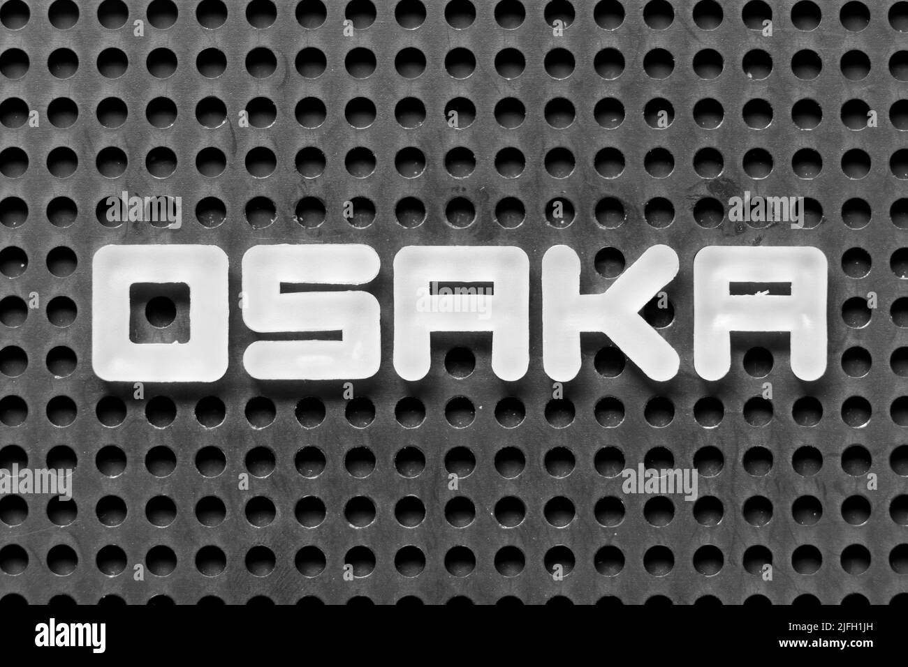 White alphabet letter in word osaka on black pegboard background Stock ...