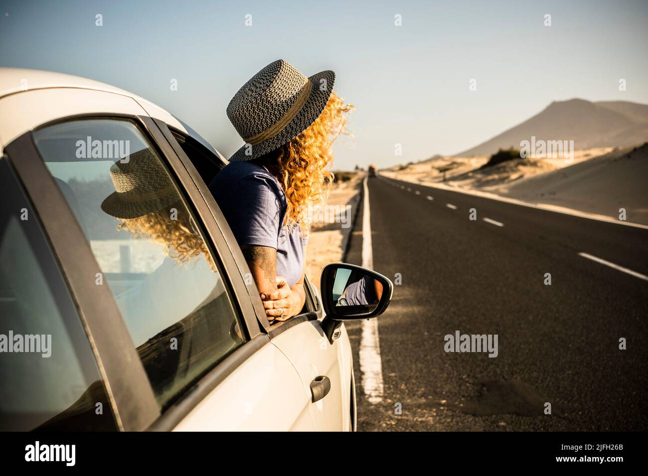 Tourist enjoy sun and outdoors outside the window of the car during a ...