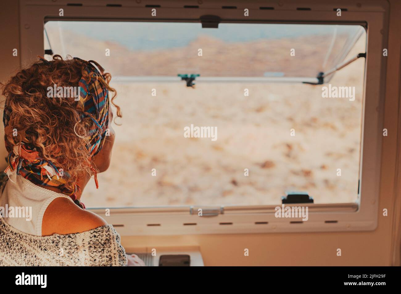 Back view of traveler woman looking outside the camper van window. Van ...