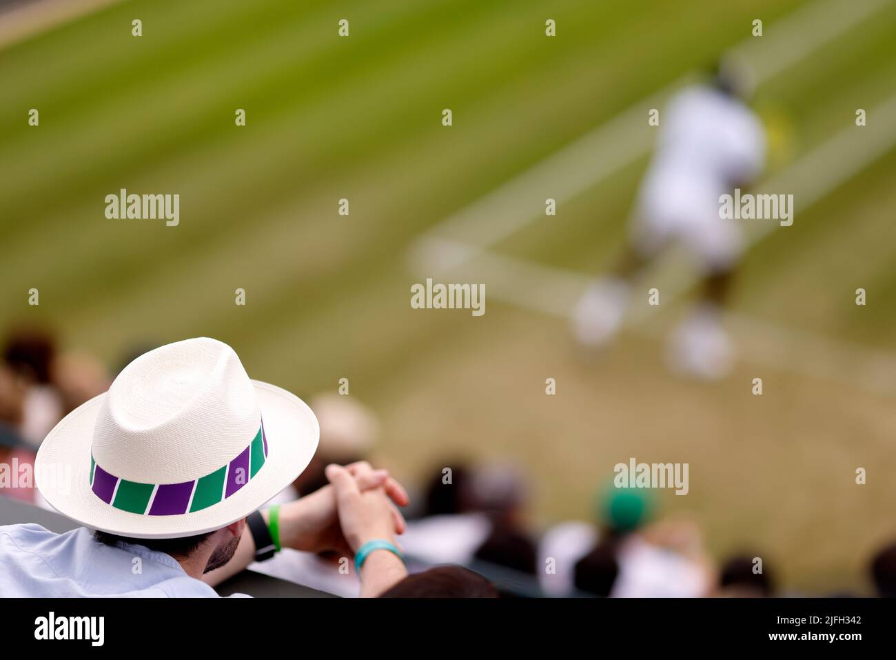 A spectator wearing a hat featuring Wimbledon colours during day seven ...