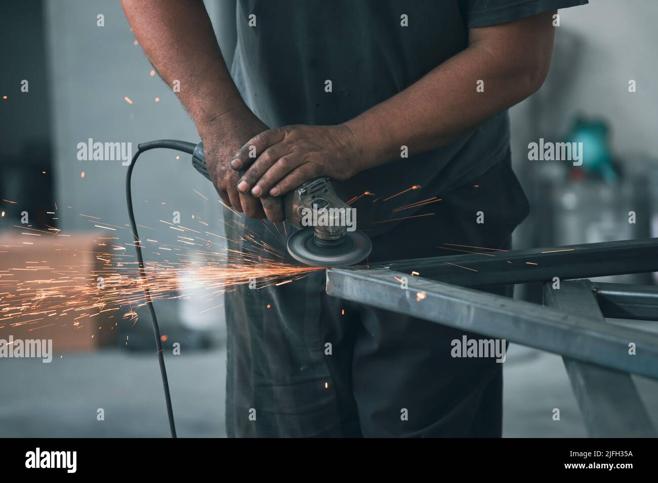 Profesional fabric worker cutting metal profile on the work table with ...