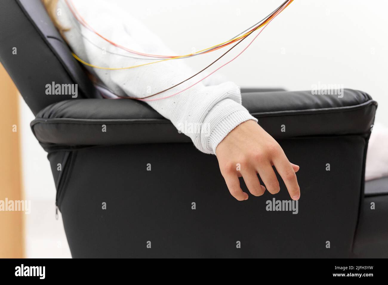 Relaxed arm of a patient sitting in a chair during a biofeedback ...