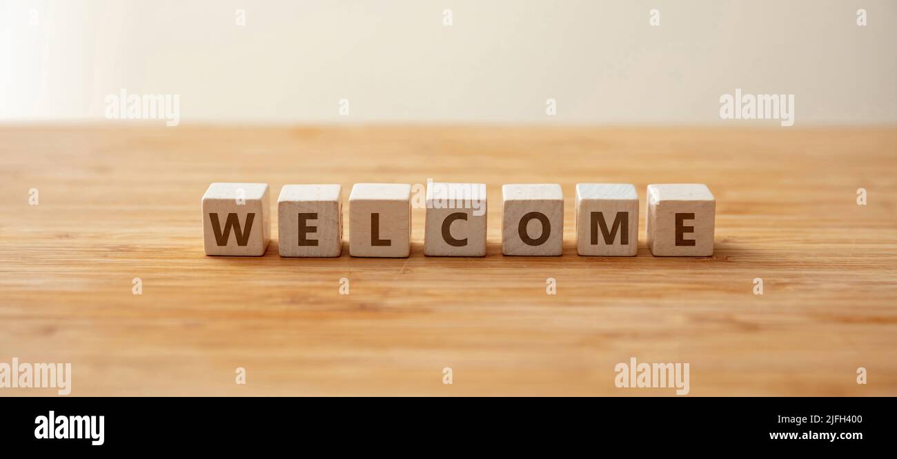 Welcome text on wooden cube on wooden table background, hospitality ...