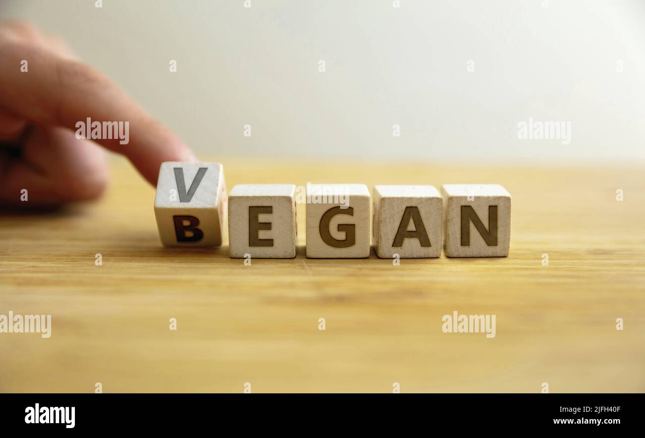 Began vegan lifestyle concept. Finger flips letter at wooden cube ...