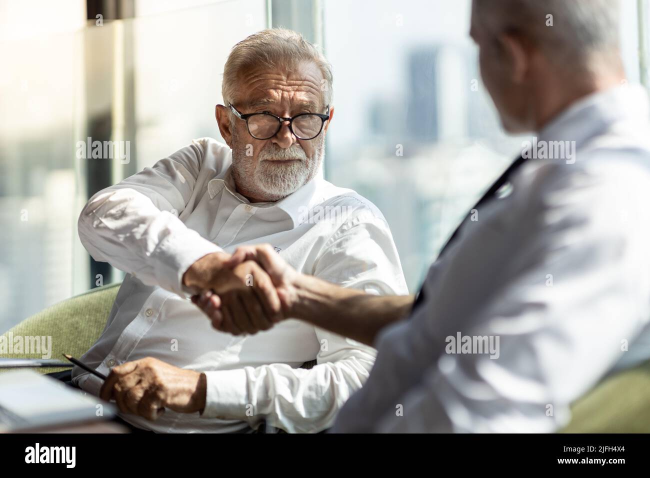 Picture of two business men negotiating over a deal. One man is in his ...
