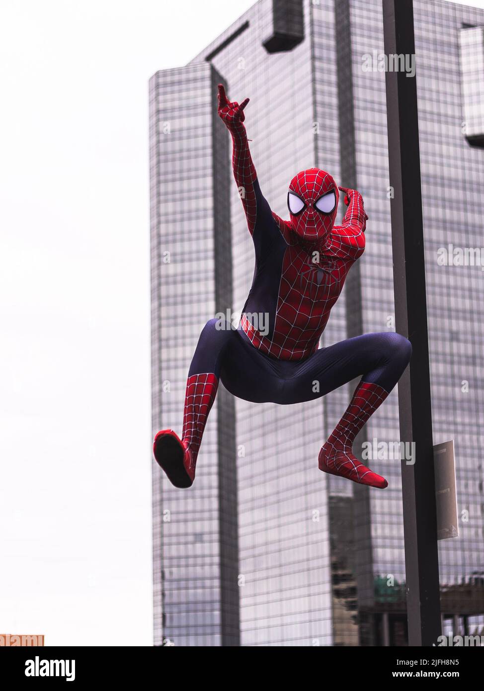 A vertical shot of Spider-Man during flight in background of glass ...