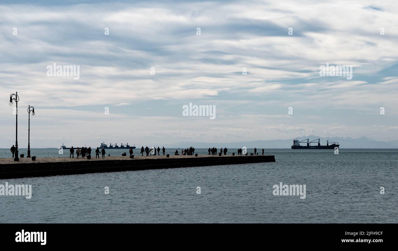 A silhouette of people on a dock on a cloudy morning Stock Photo - Alamy