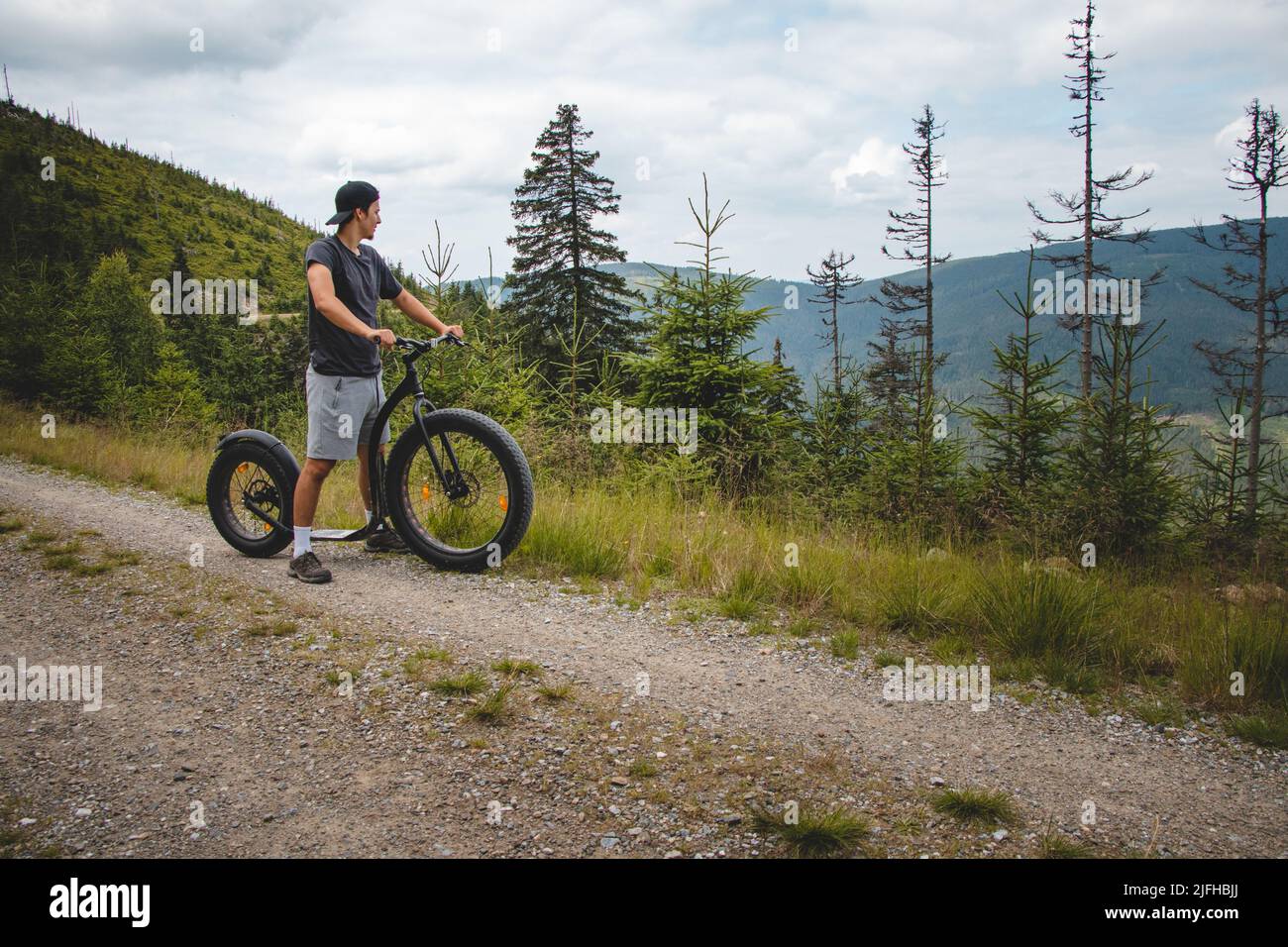 Swarthier type of person rides a downhill mountain scooter on a steep ...