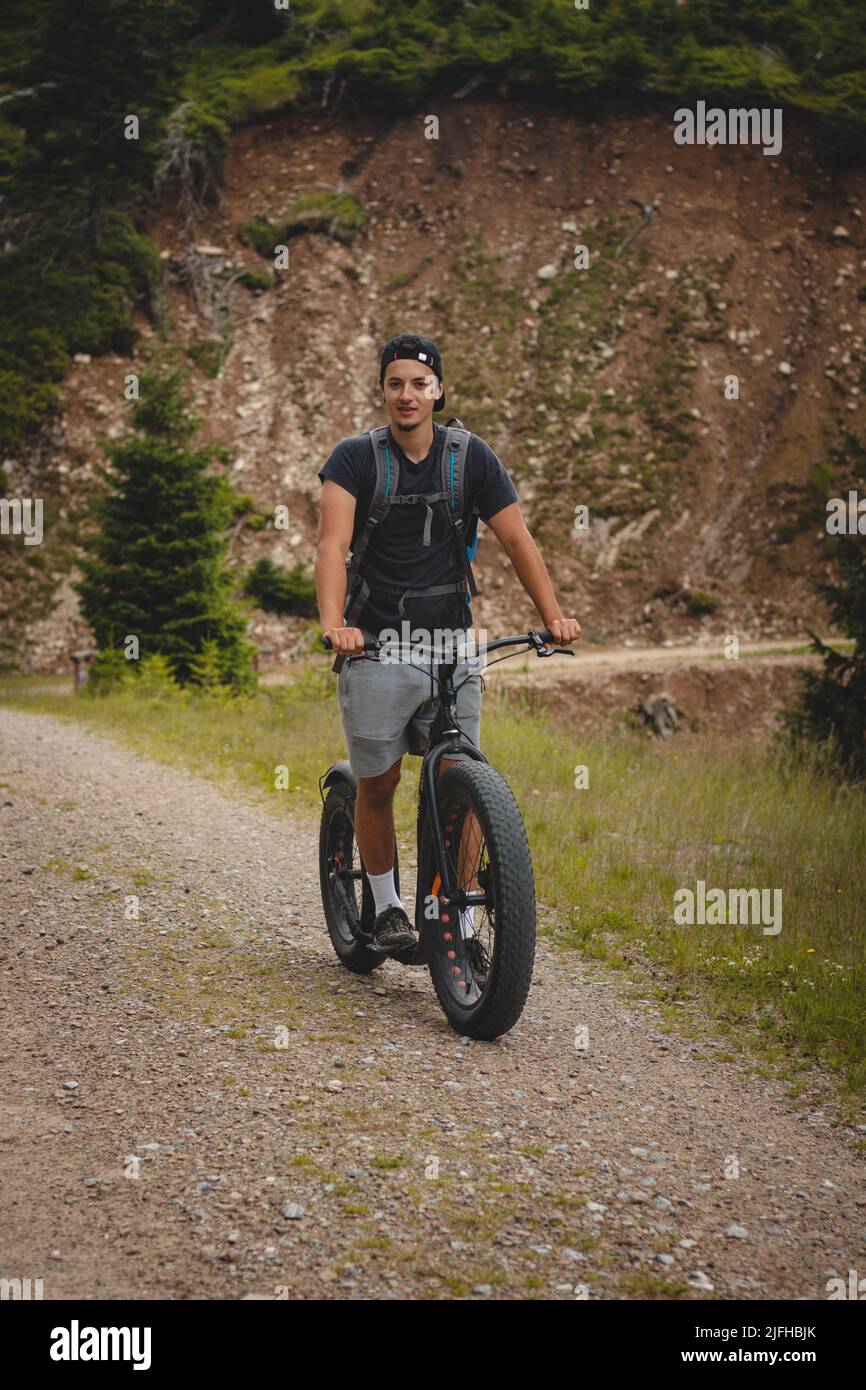 Swarthier type of person rides a downhill mountain scooter on a steep ...