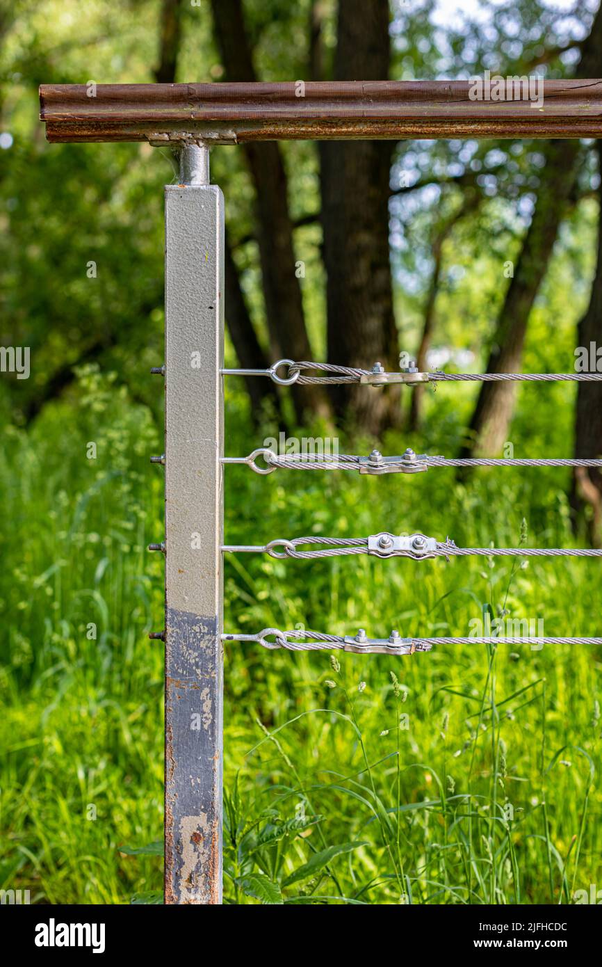 fixing a steel cable on a fence in a park. High quality photo Stock ...