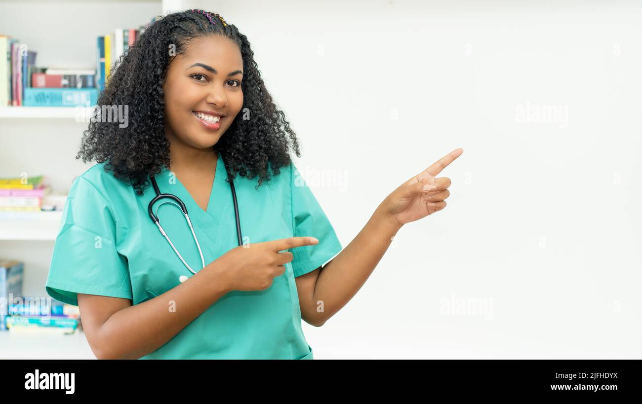 Latin american medical student or female nurse pointing sideways at clinic Stock Photo - Alamy