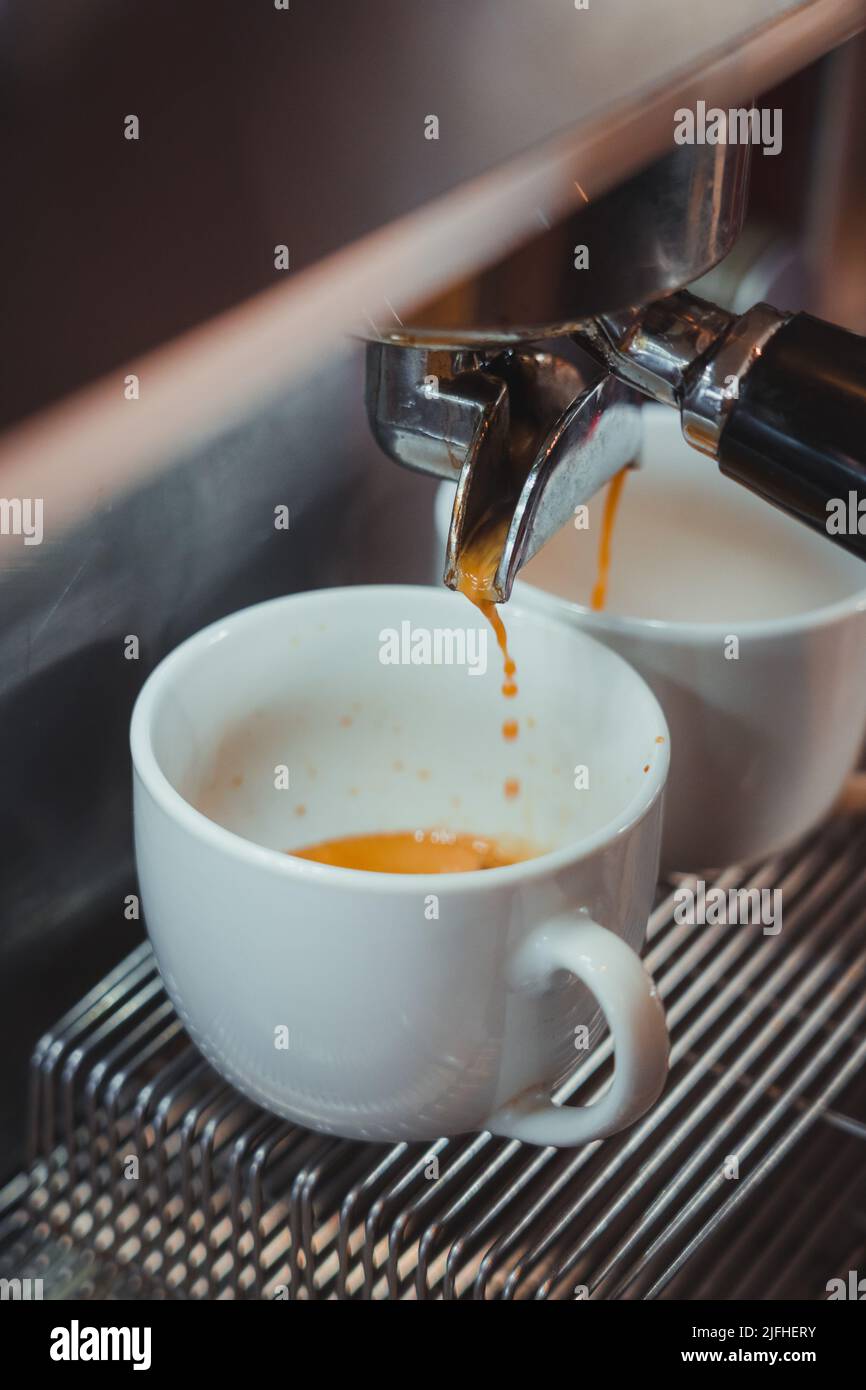 A coffee maker pouring fresh coffee into two cups Stock Photo - Alamy