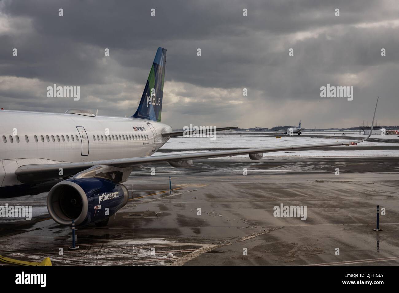 The rear end of the JetBlue airplane in the airport against the cloudy ...