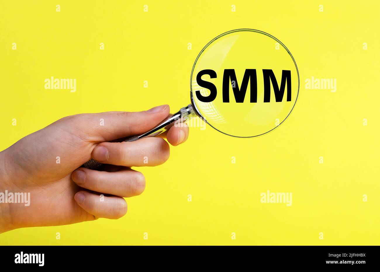 SMM word through magnifier, lens on yellow background. High quality ...